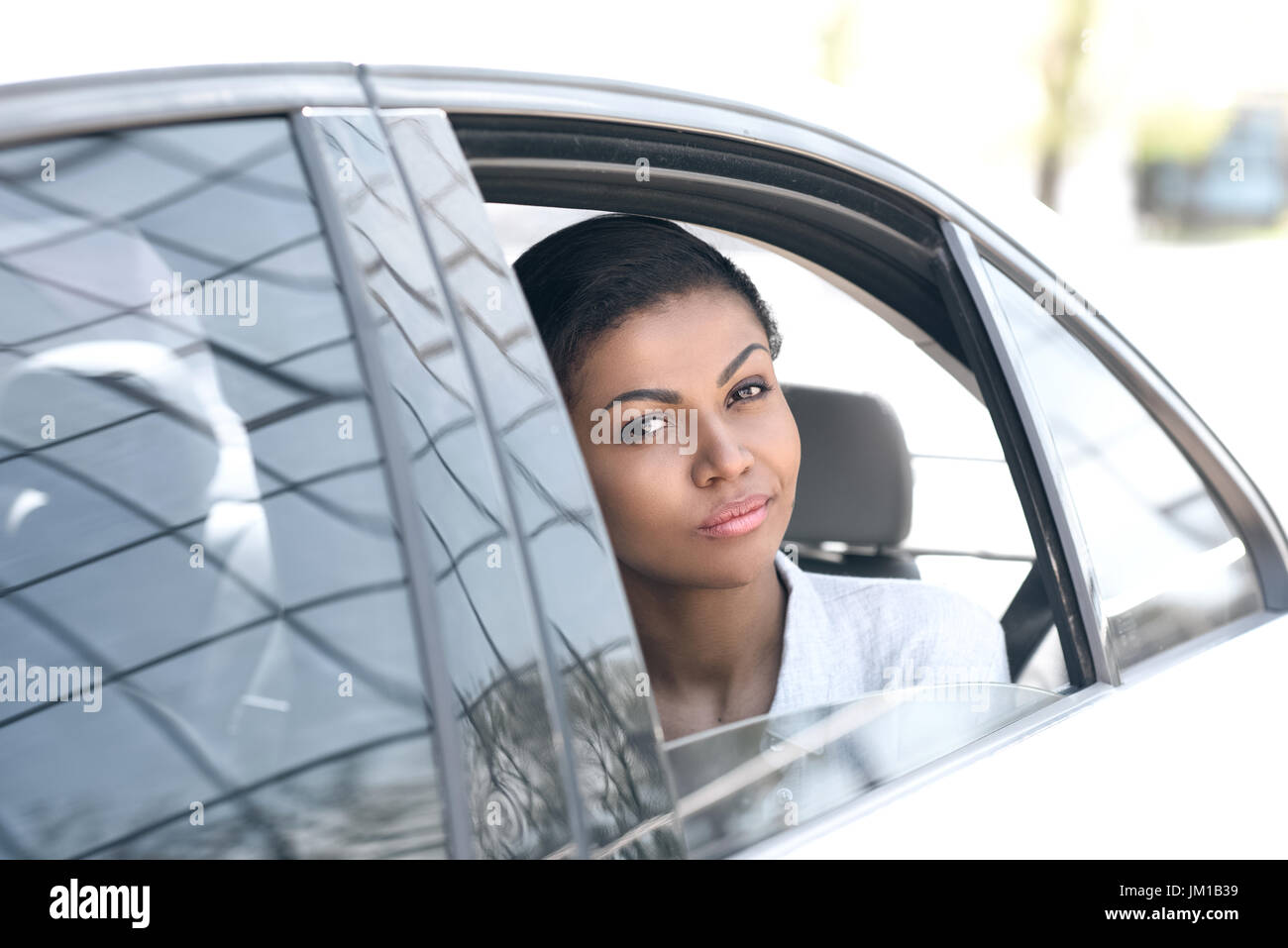 Beautiful young smiling woman looking through car window Stock Photo ...