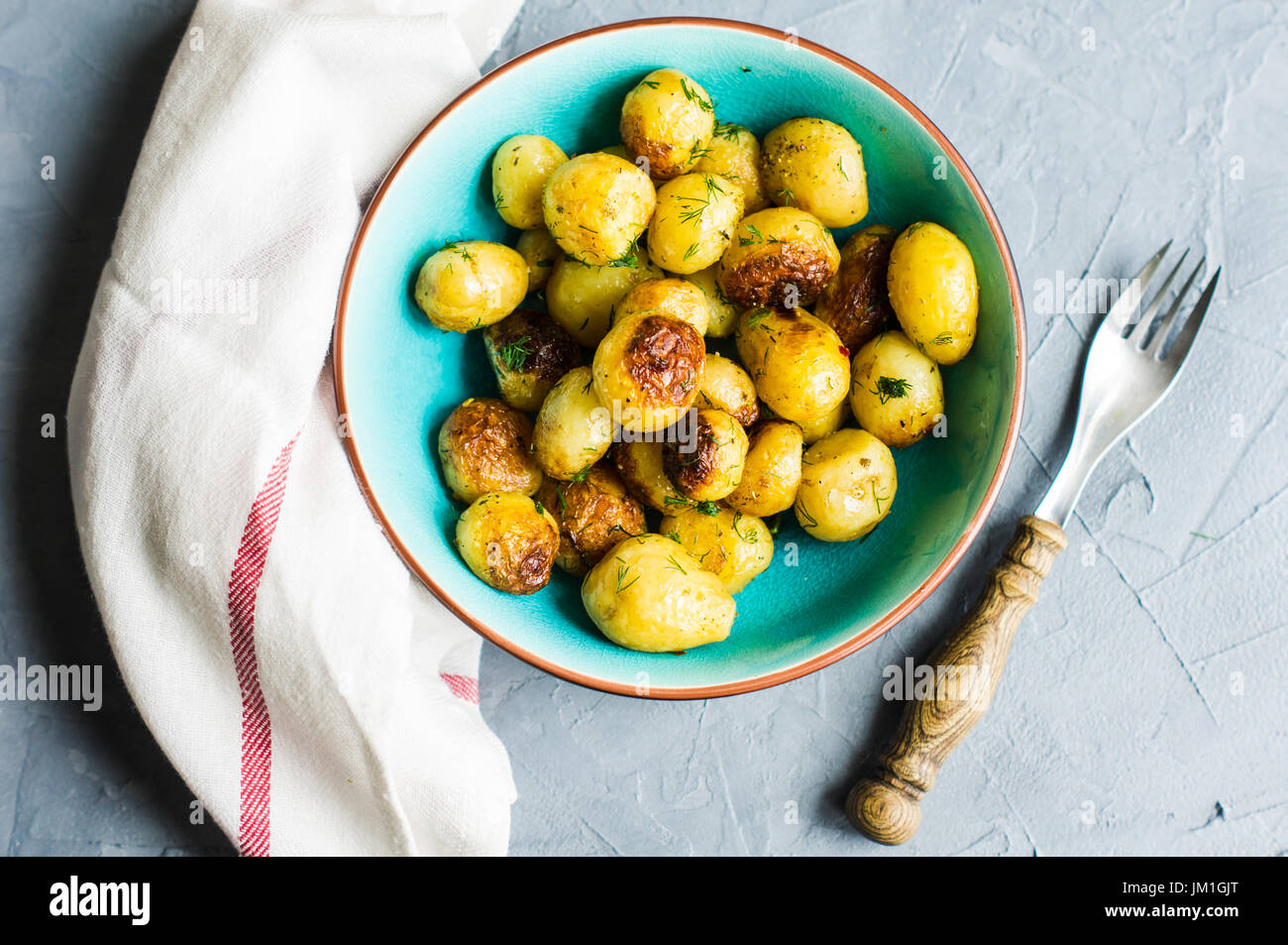 Roast potatoes seasoned with salt, garlic and provance herbs in rustic ...