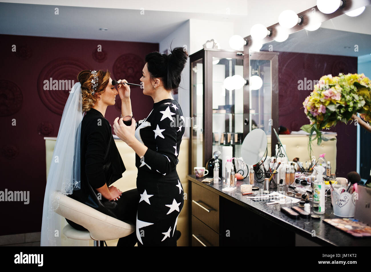 Gorgeous bride having her hair and makeup done in the beauty salon ...