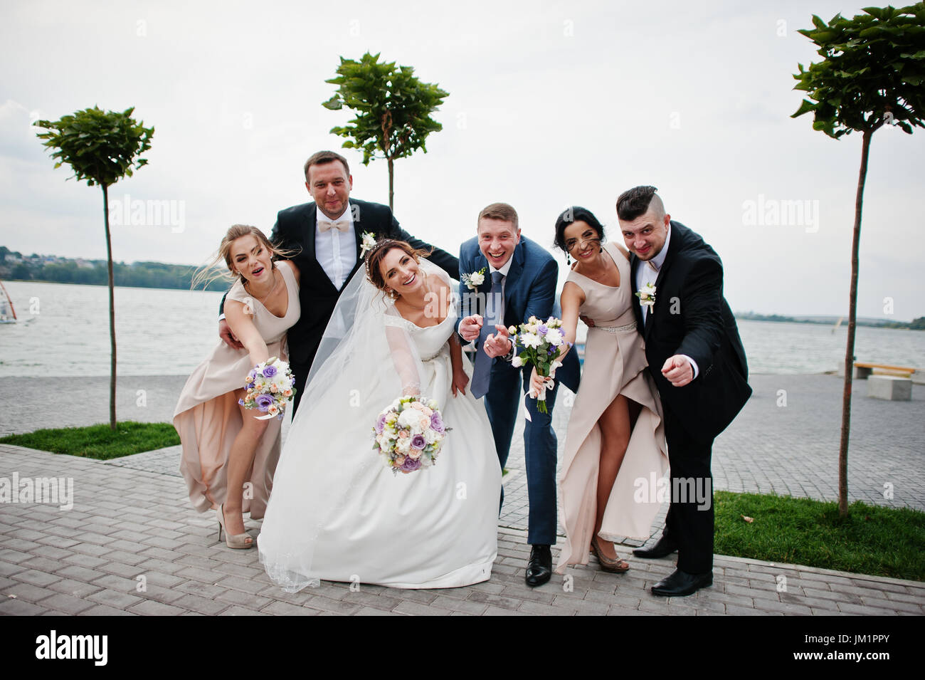 Amazing wedding couple and crazy groomsmen with bridesmaids having fun ...