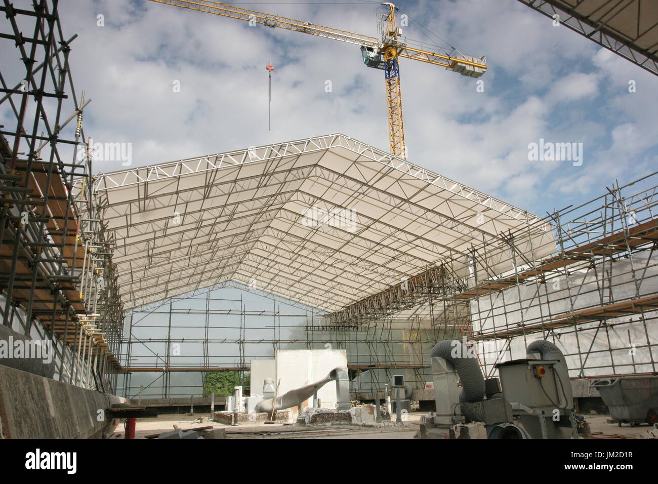 A large, temporary scaffolding roof covers a college building in ...