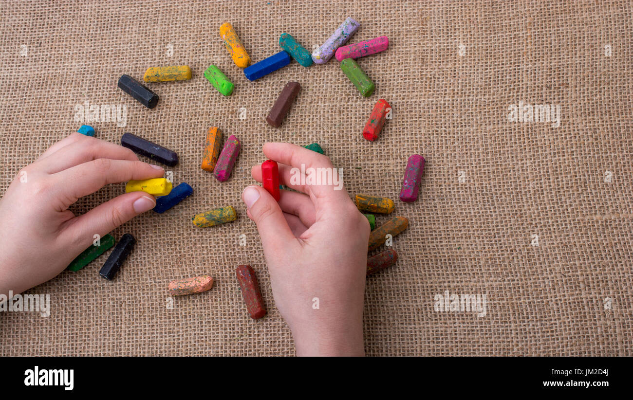 Used color crayons and a hand holding some Stock Photo - Alamy