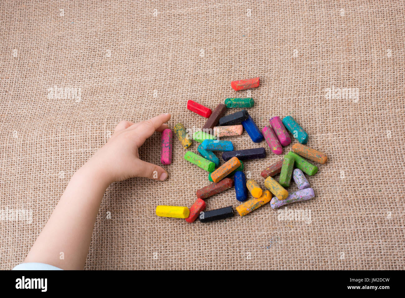 Used color crayons and a toddlers hand holding one Stock Photo - Alamy
