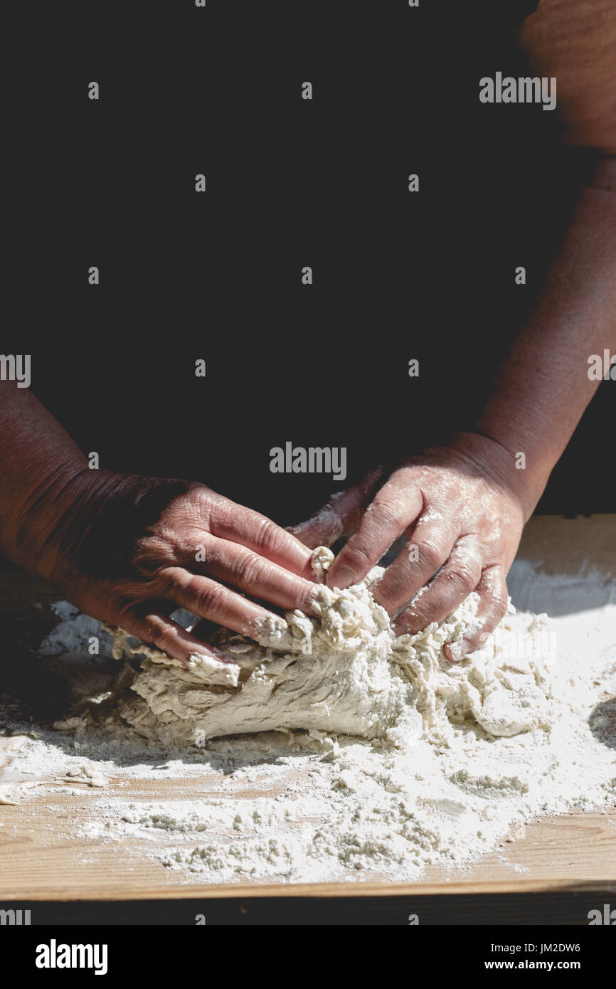 Grand mother kneading pastry for Christmas baking. Vertical crop, faded ...