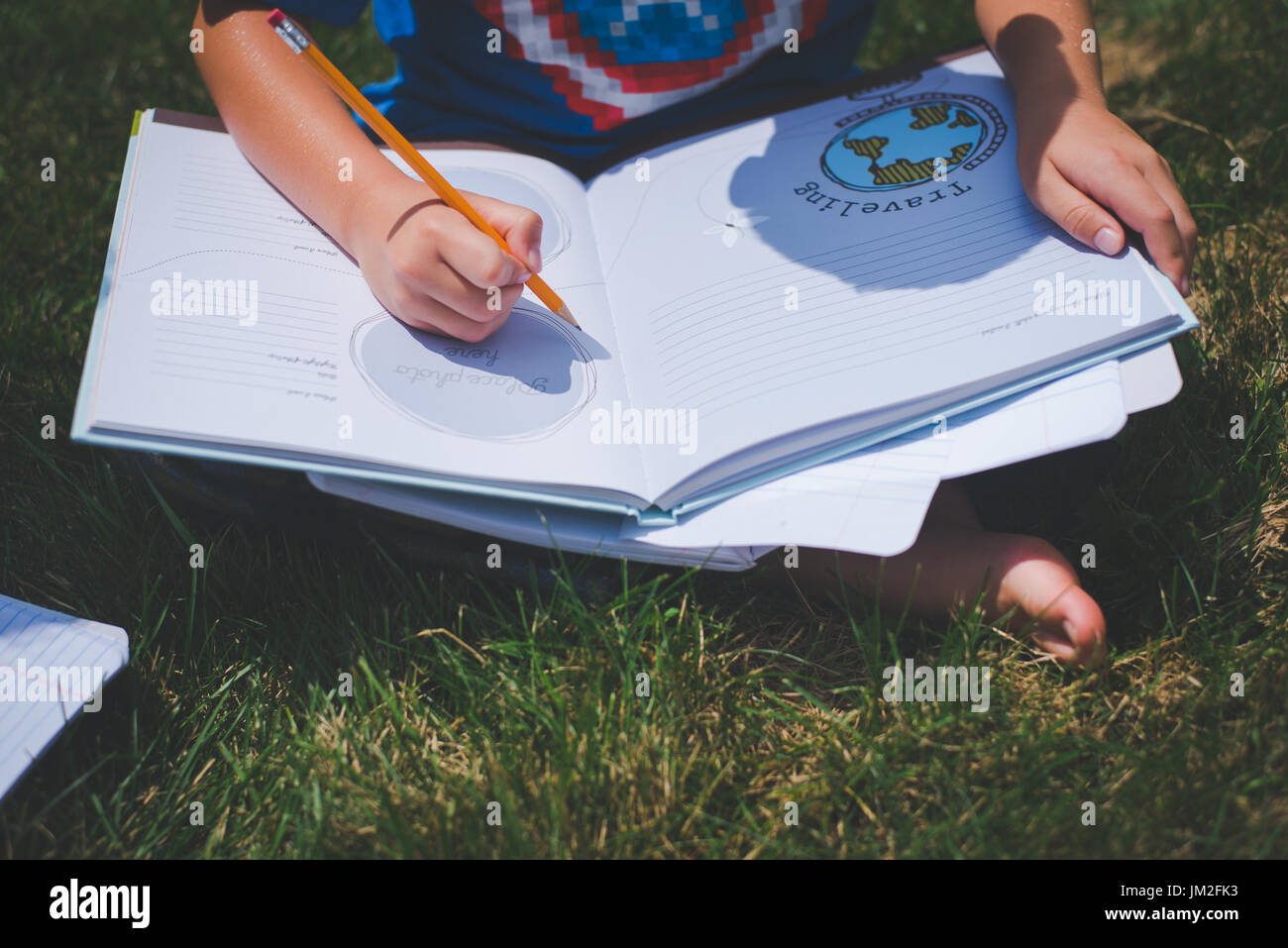 A youth writes in a notebook for school education learning back to ...