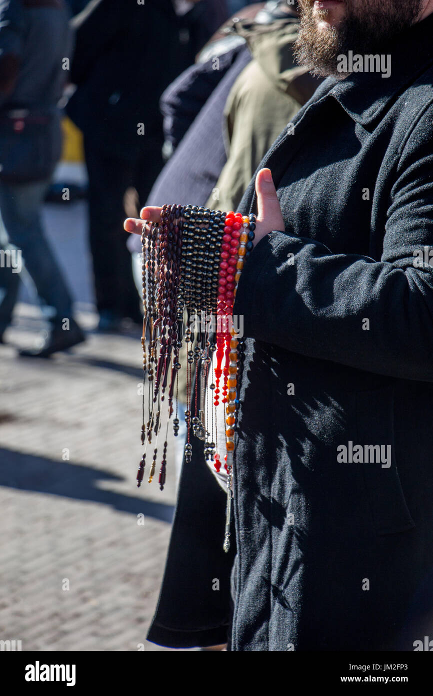 Set of praying beads of various colors in hand in a marketplace Stock ...