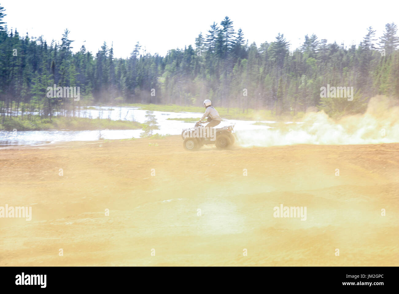 Man driving ATV quad in sandy terrain with high speed Stock Photo - Alamy