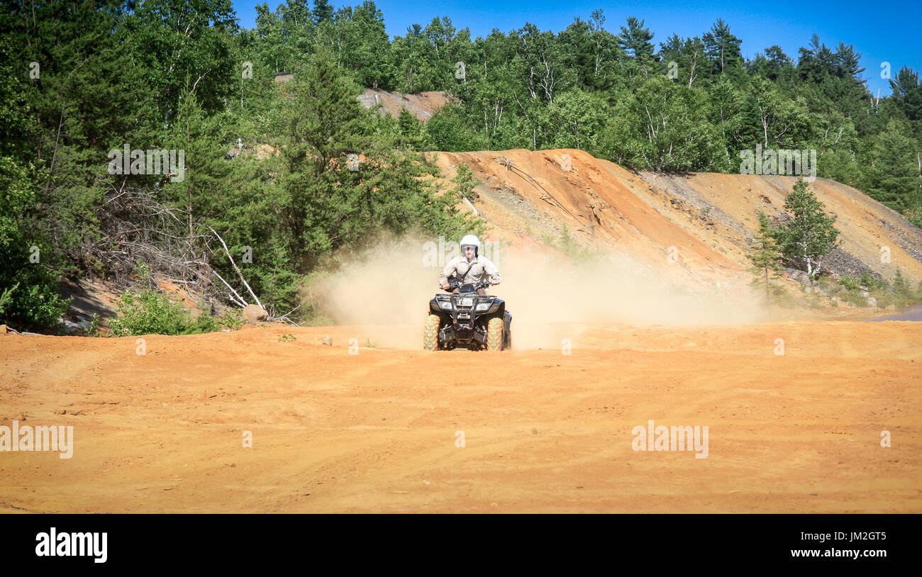 Man driving ATV quad in sandy terrain with high speed Stock Photo - Alamy