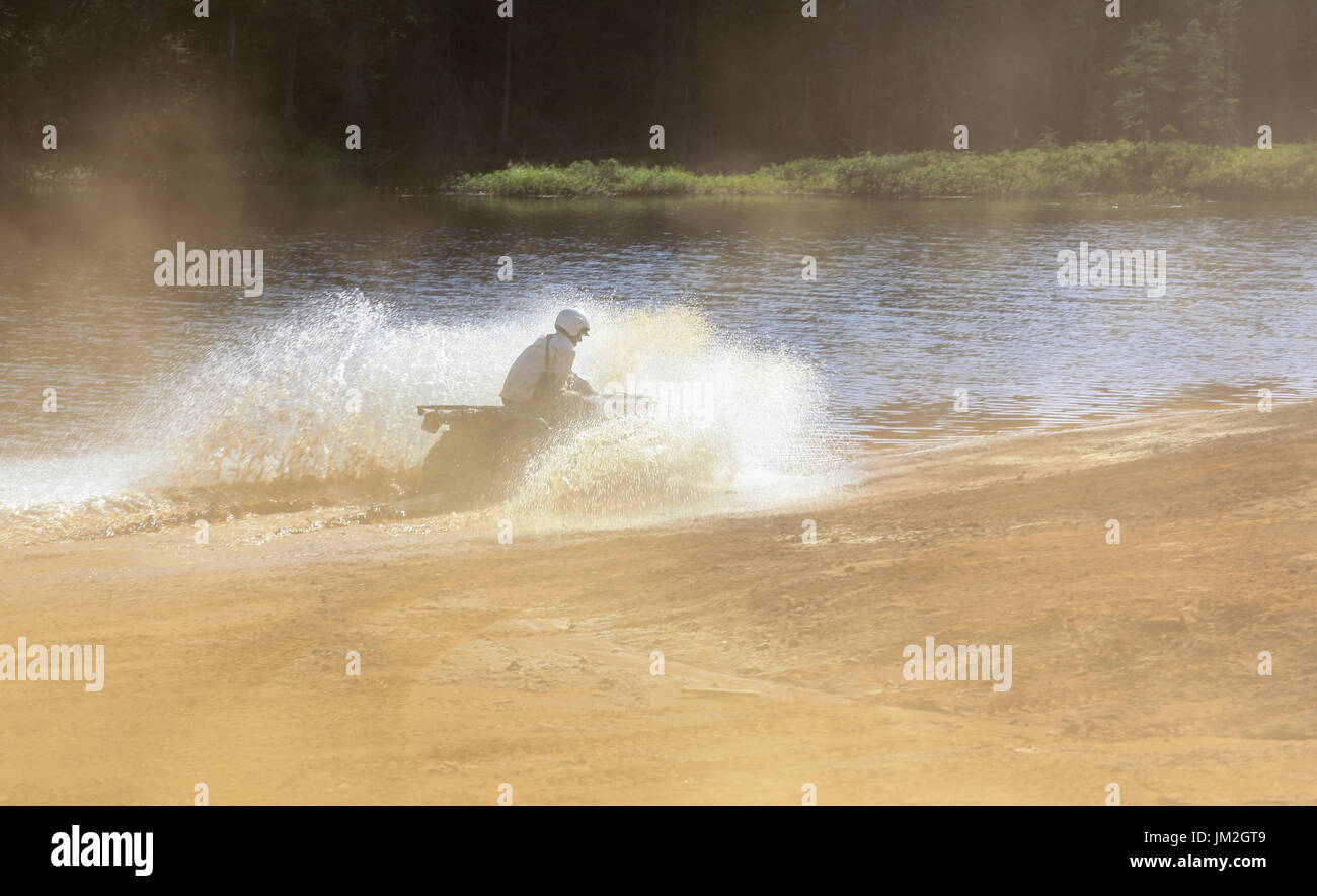 Man driving ATV quad through splashing water with high speed Stock ...