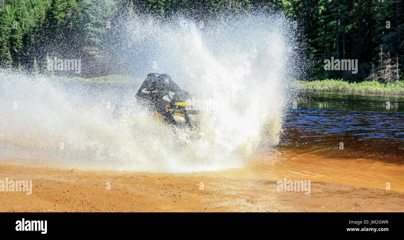 Man driving ATV quad through splashing water with high speed Stock ...