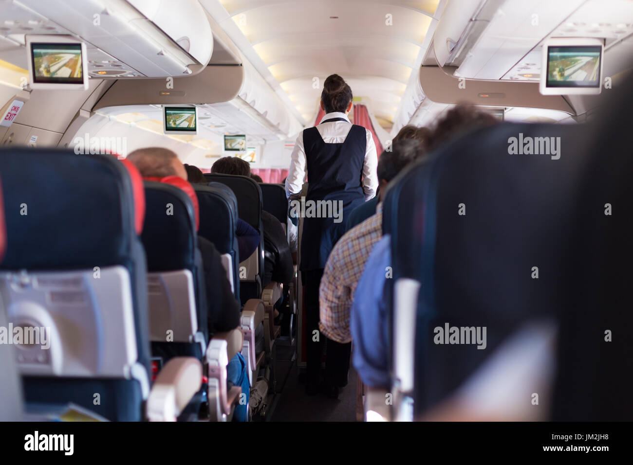 Interior of commercial airplane with passengers on seats during flight ...