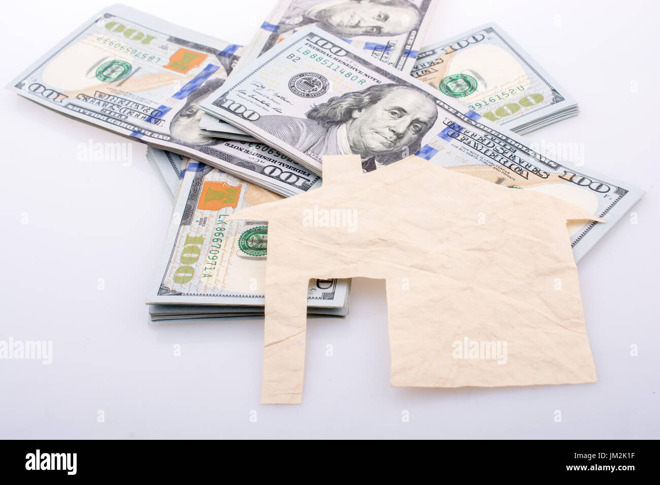 Paper house placed beside a bundle of US dollar banknote Stock Photo ...