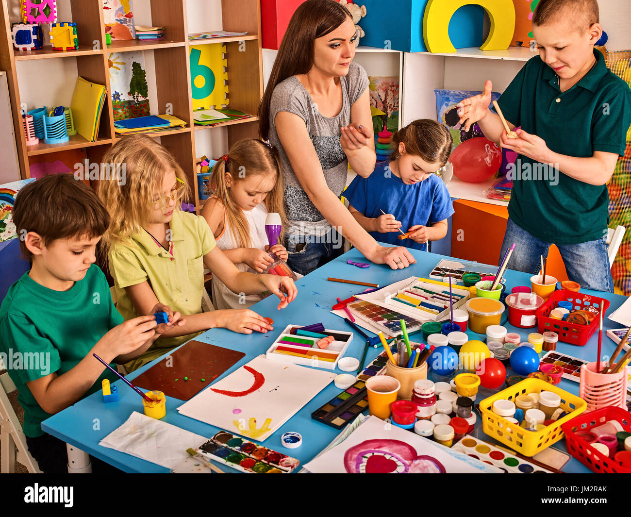 Plasticine modeling clay in children class. Teacher teaches in school ...