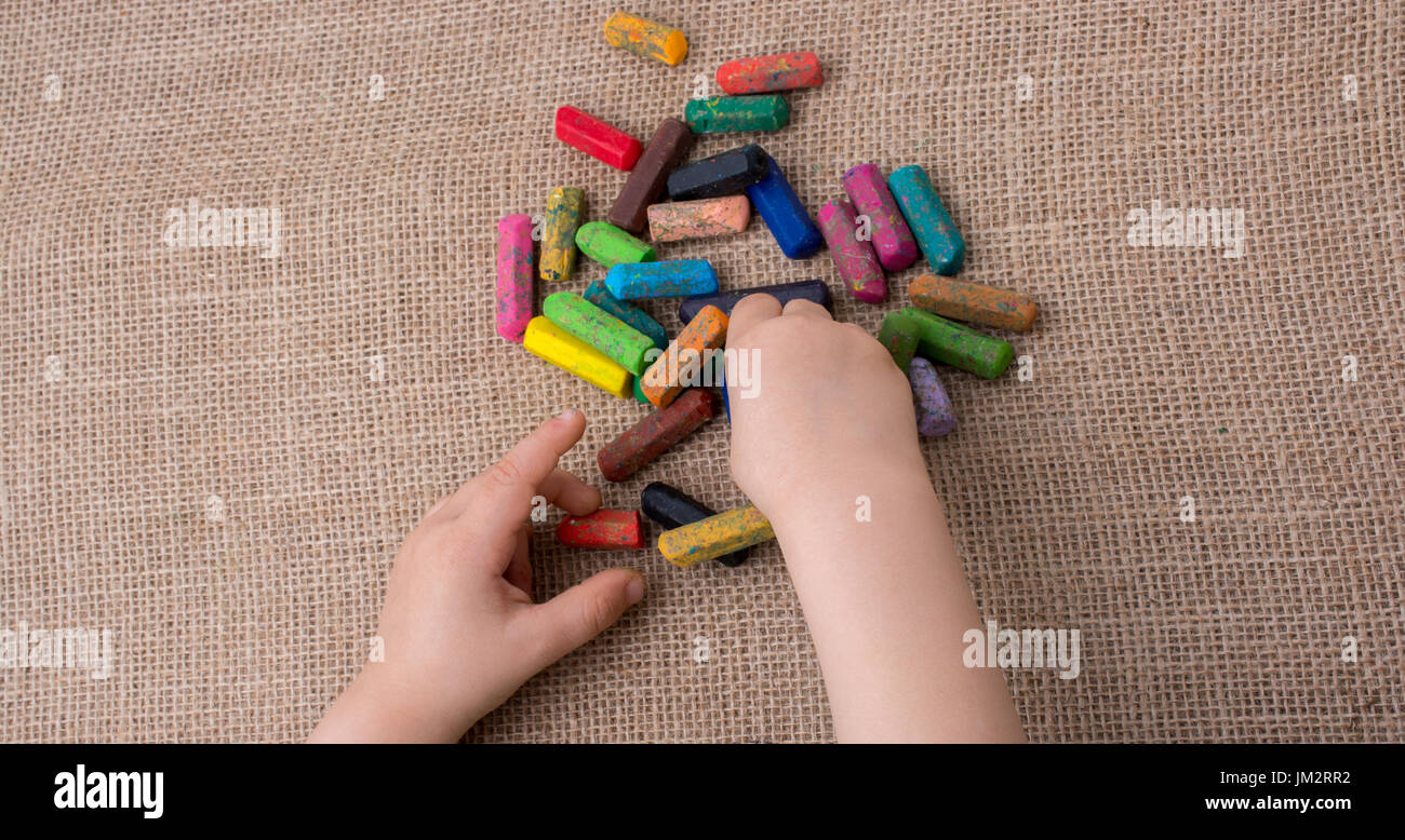 Used color crayons and a toddlers hand holding one Stock Photo - Alamy