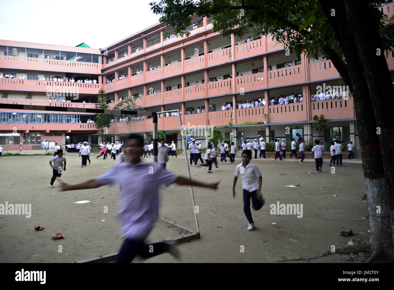 Bangladeshi school students walking on the school ground at class break ...