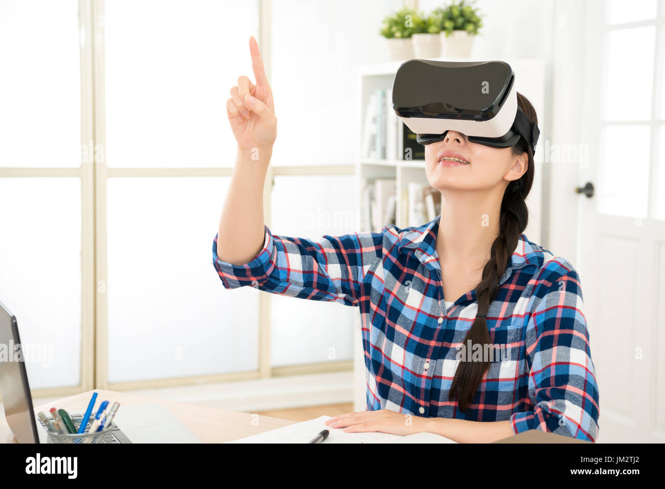 mixed race asian chinese model excited using a VR headset and touch ...