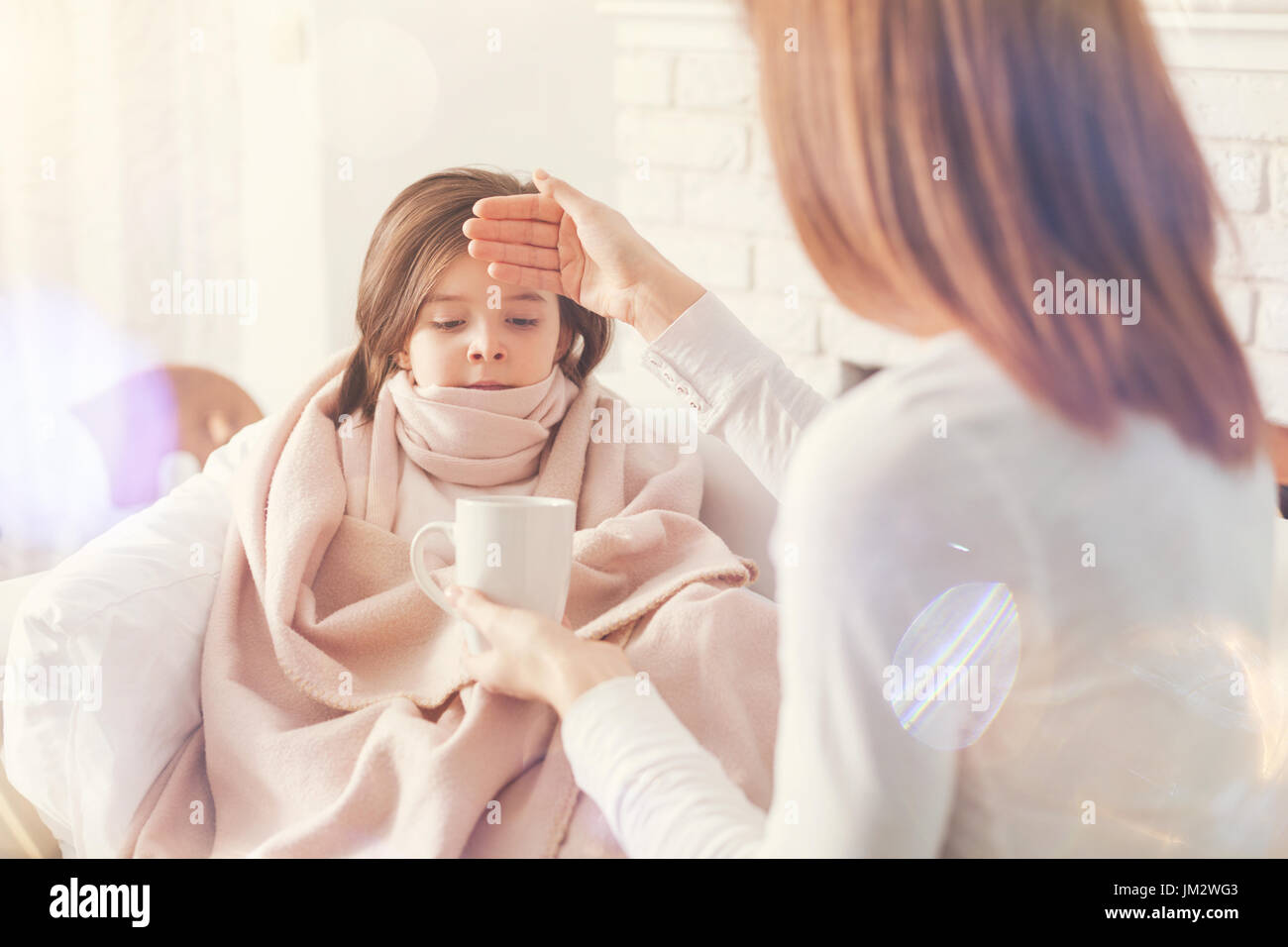 Sick girl looking at white cup Stock Photo - Alamy