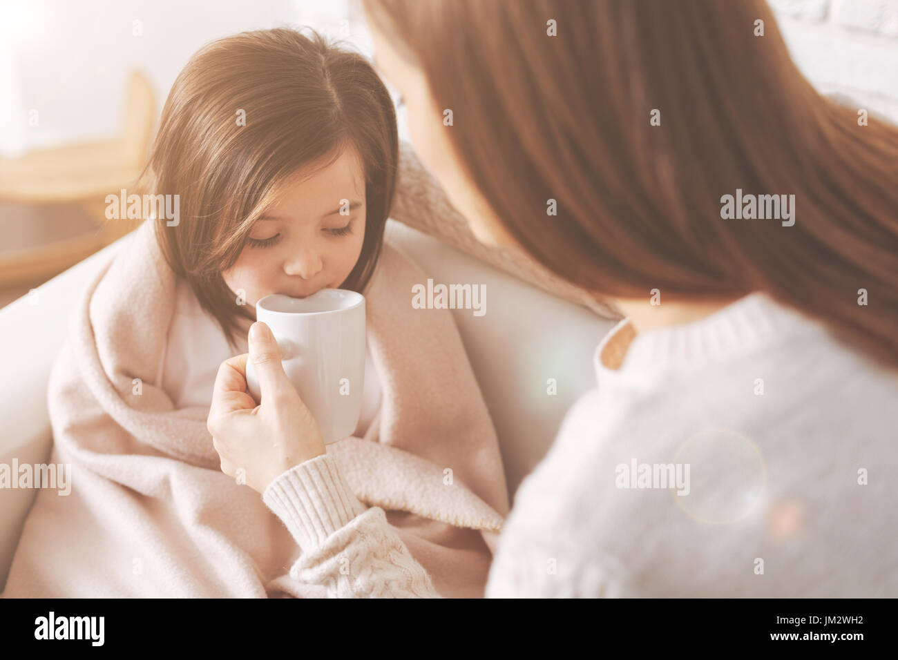 Sad girl going to take warm mixture Stock Photo - Alamy