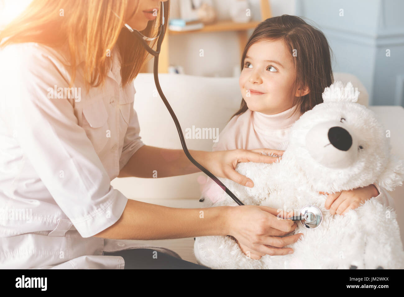 Shy kid looking at serious doctor Stock Photo - Alamy