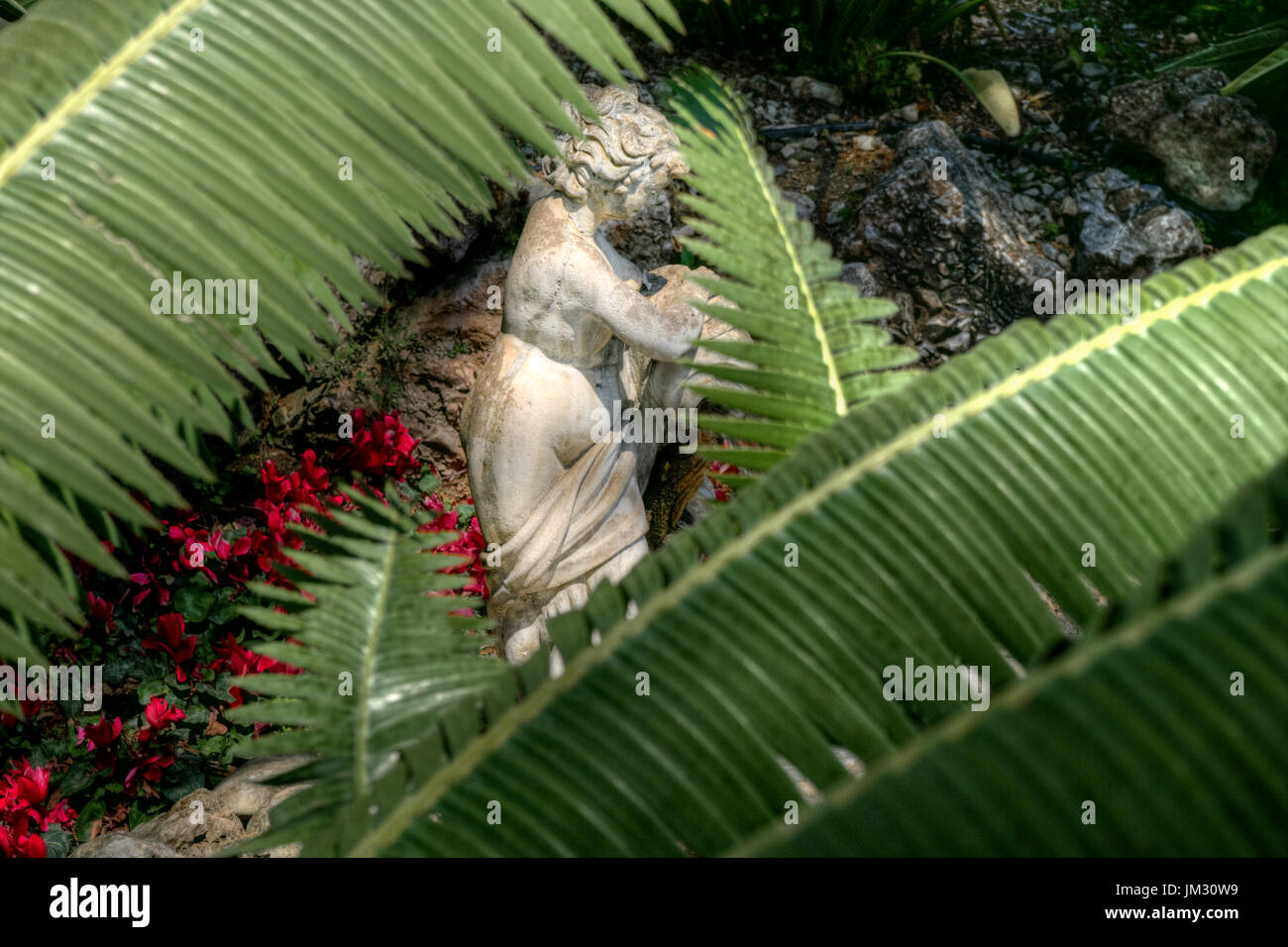 Statue of naked girl semi-draped in cloth collecting water. She is ...