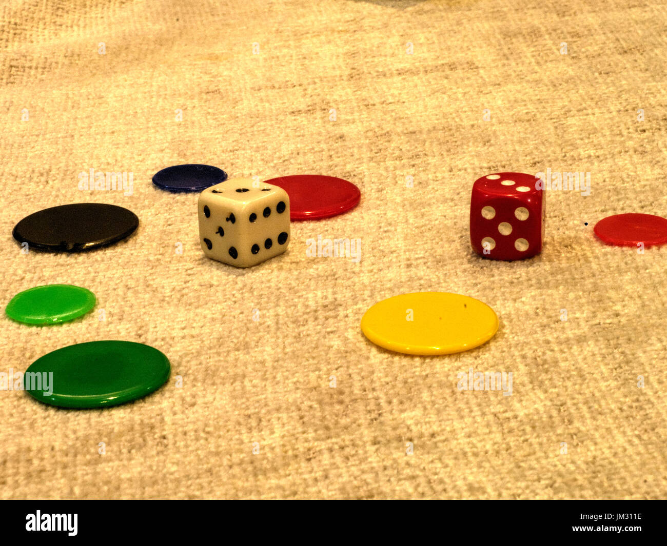 Two dice and seven counter lying on a table Stock Photo - Alamy