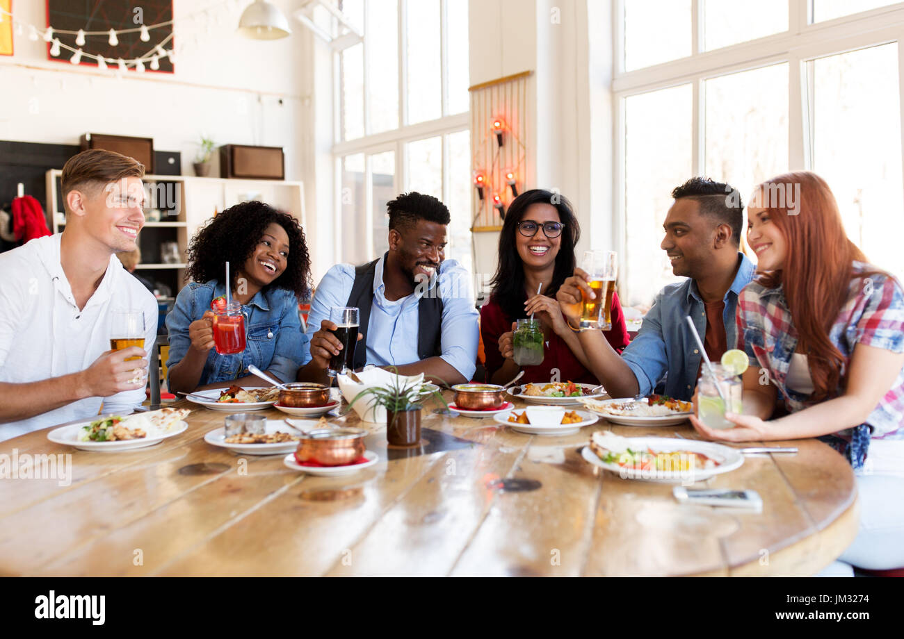 happy friends eating and drinking at restaurant Stock Photo - Alamy