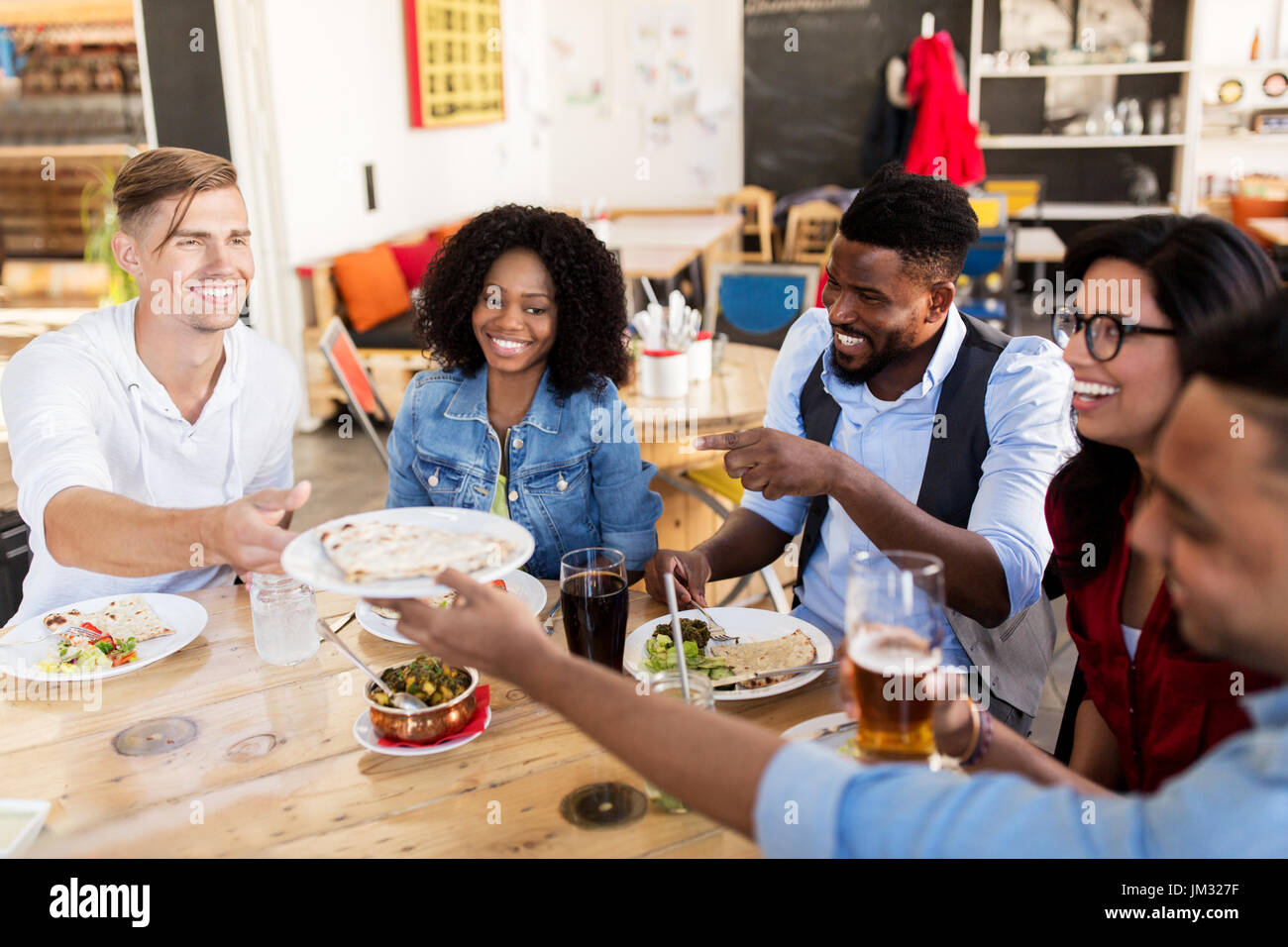 happy friends eating at restaurant Stock Photo - Alamy