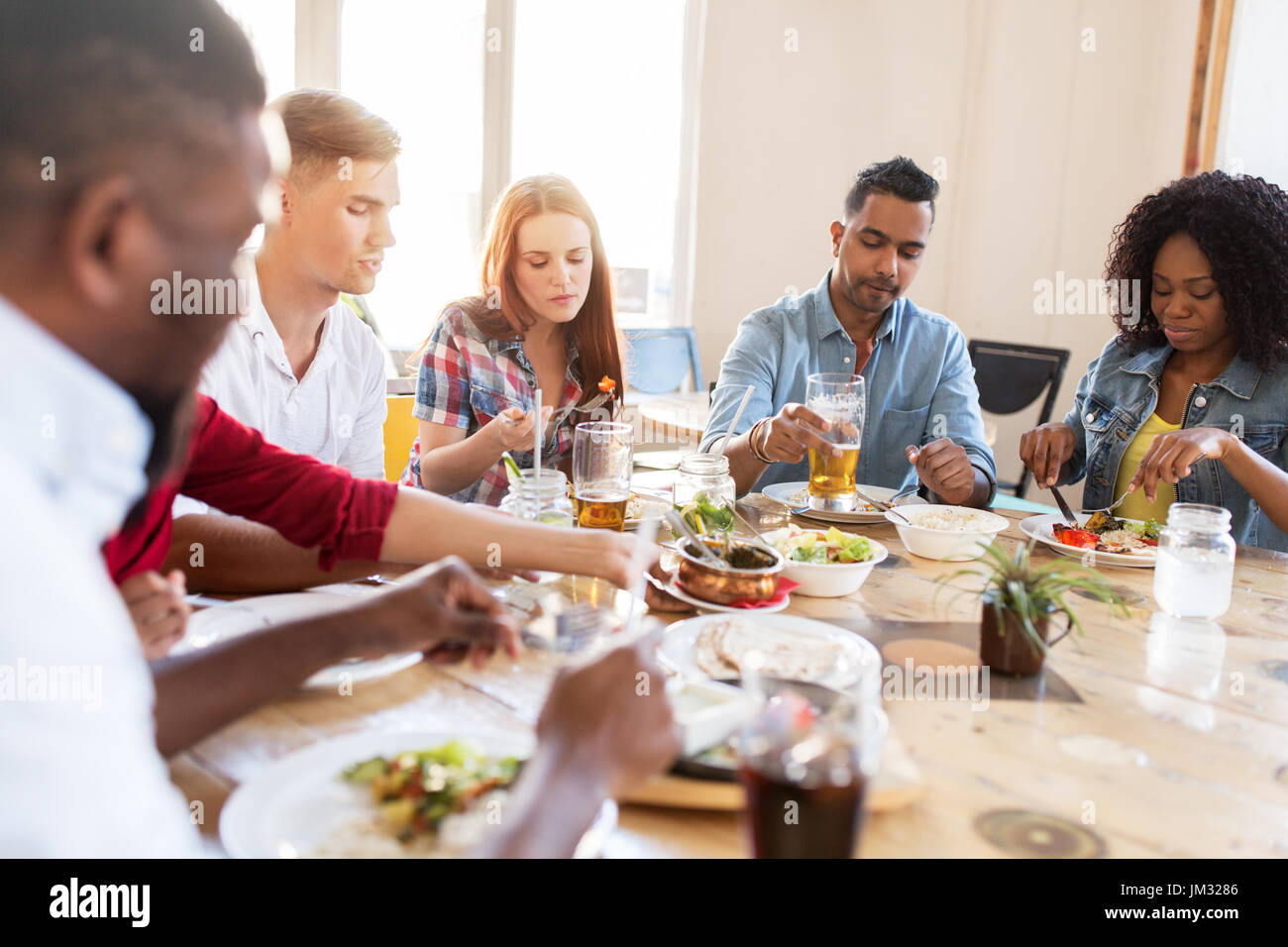 friends eating at restaurant Stock Photo - Alamy