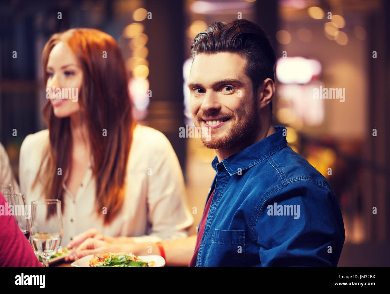 happy man with friends having dinner at restaurant Stock Photo - Alamy
