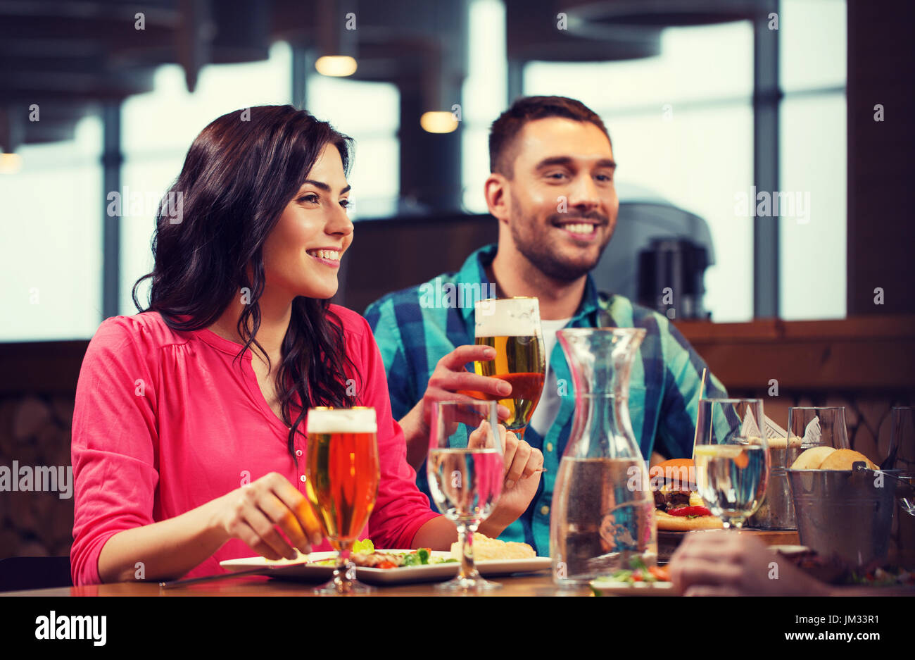 friends dining and drinking beer at restaurant Stock Photo - Alamy