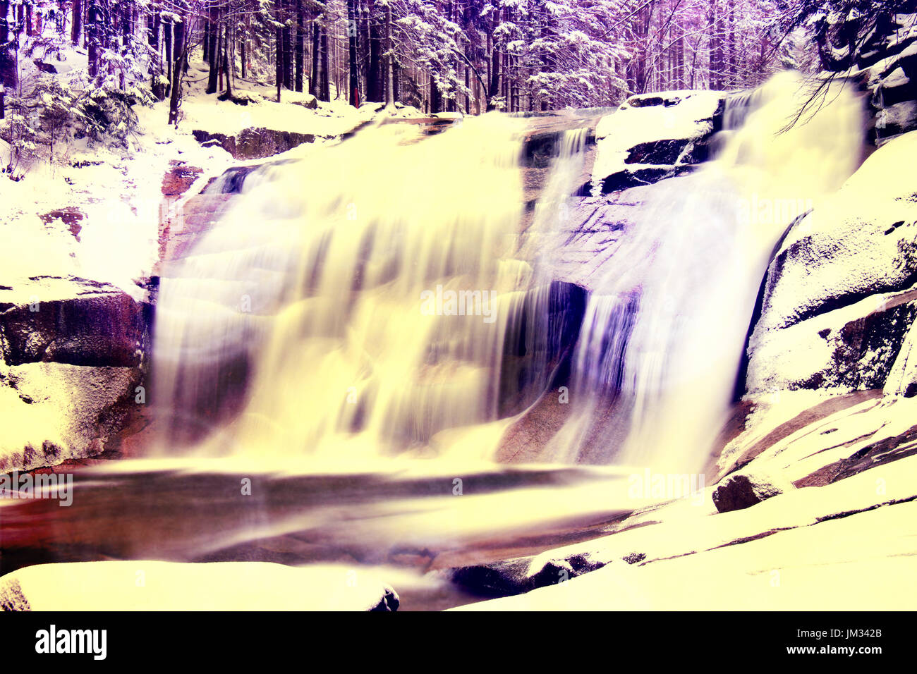 Film grain effect. Winter view over snowy boulders to cascade of ...
