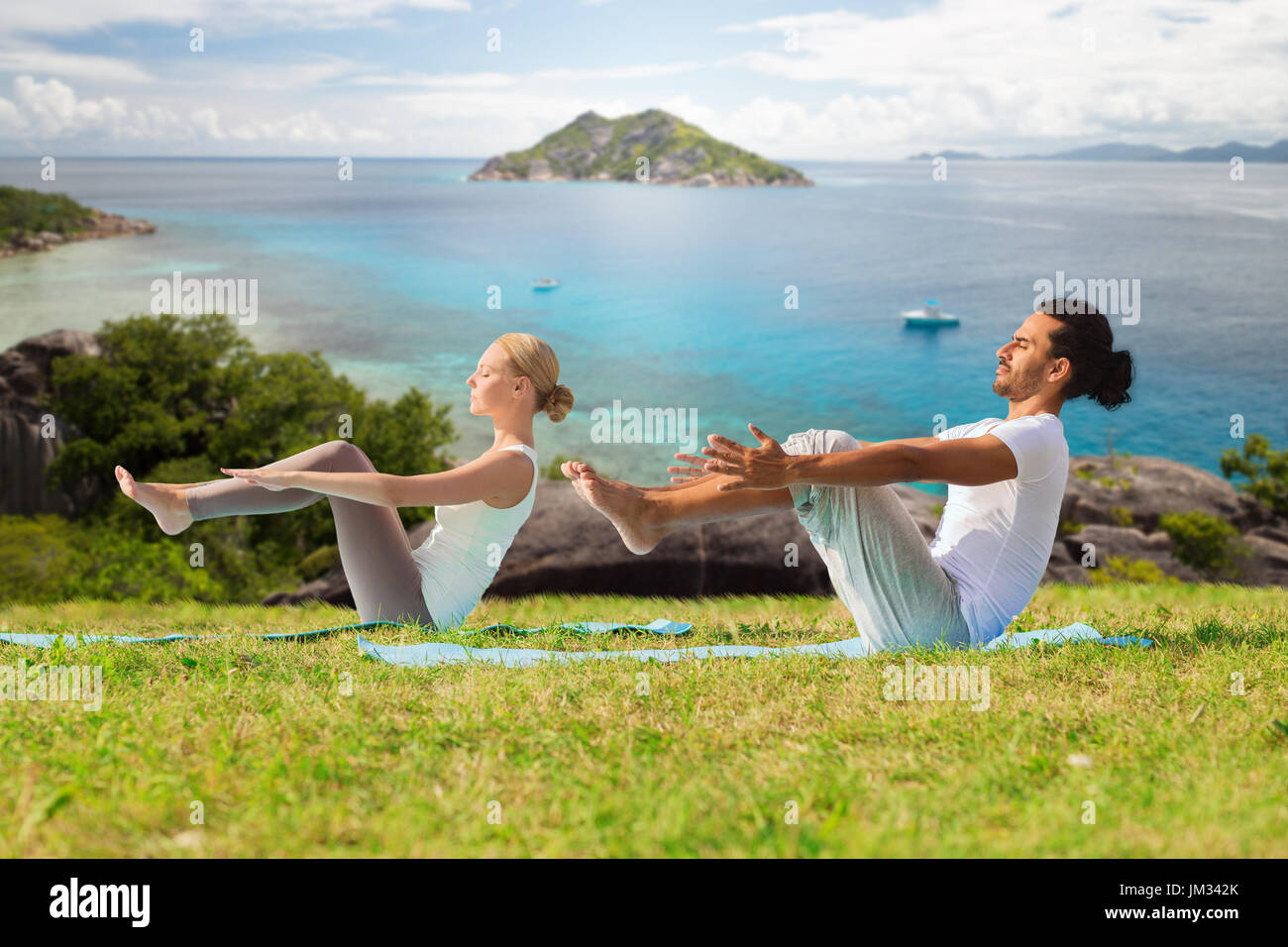 couple making yoga half-boat pose outdoors Stock Photo - Alamy