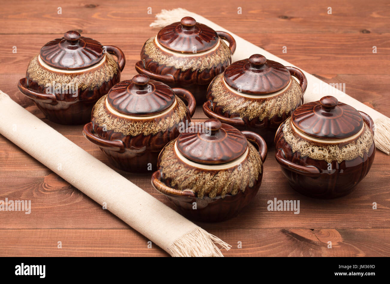 Clay pots for cooking with background on a wooden table and napkins ...