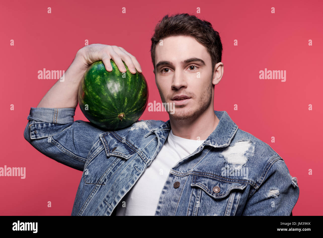 portrait of young handsome casual man holding watermelon, attractive ...