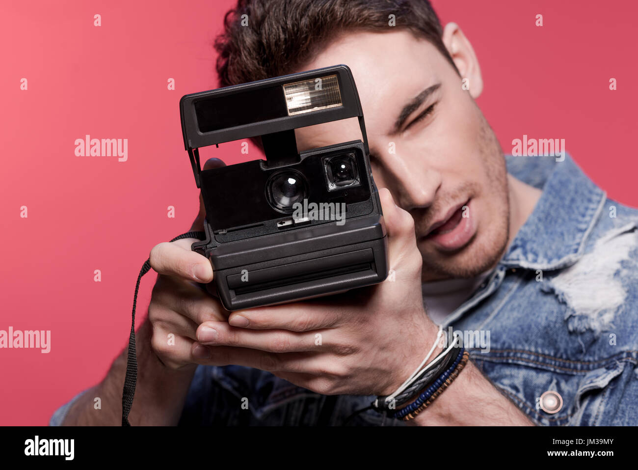 portrait of young handsome casual man using vintage camera, attractive ...