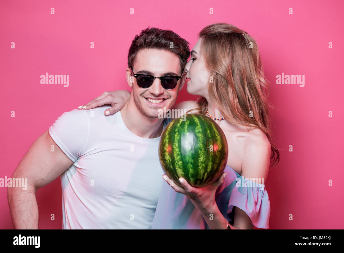 Stylish young couple in love posing with fresh ripe watermelon isolated ...