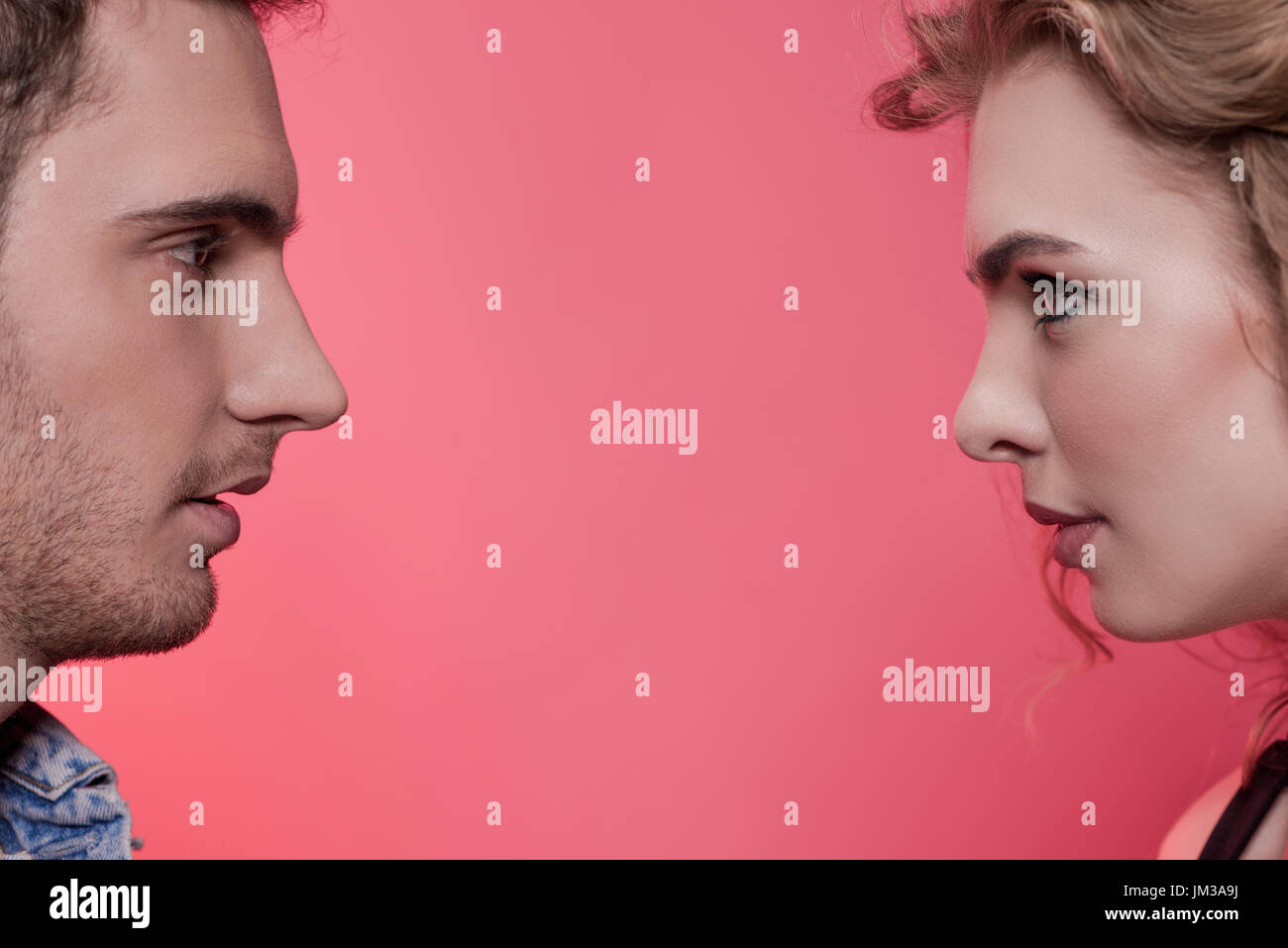 side view of stylish young couple in love looking at each other ...