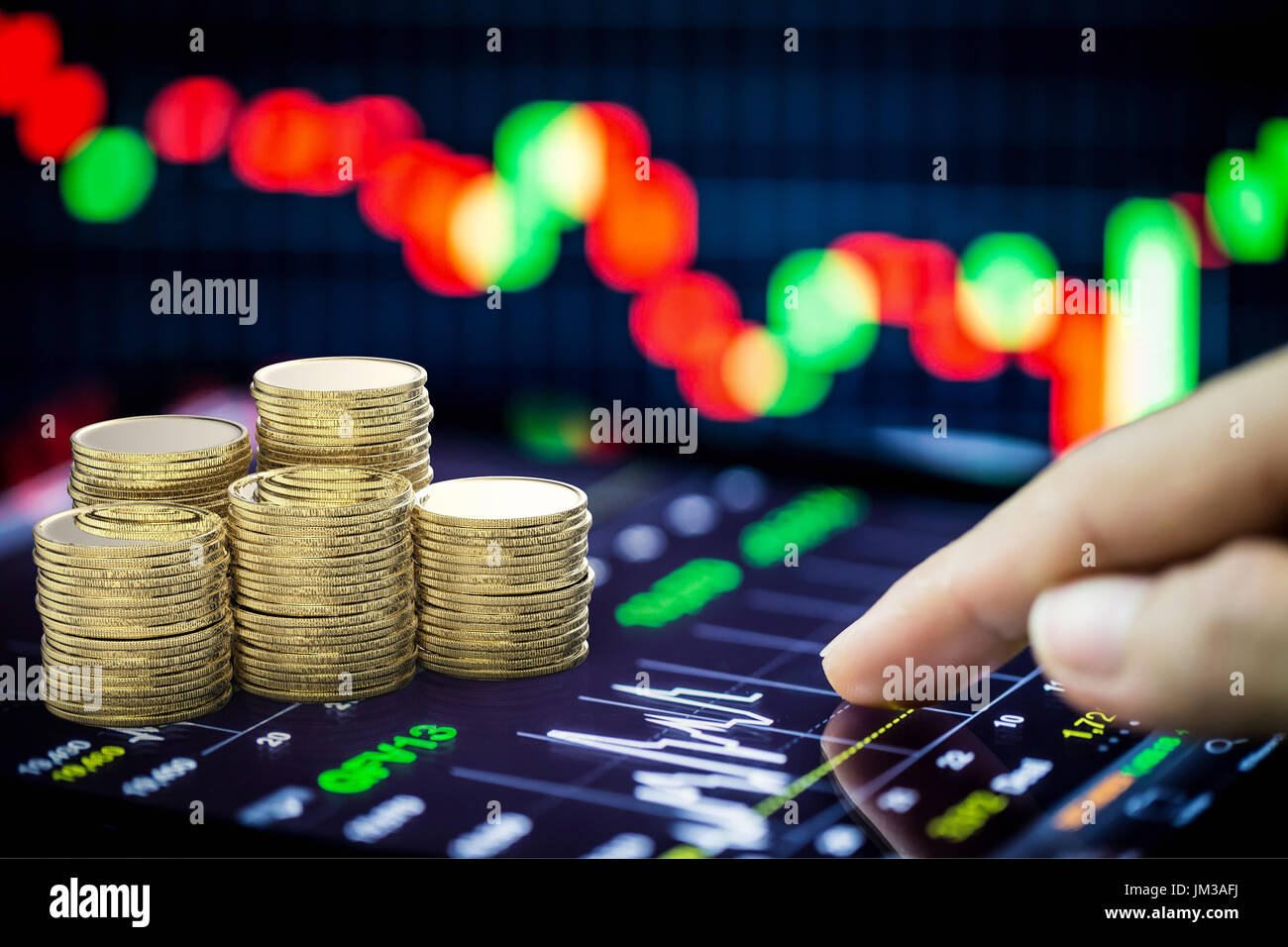 stock market watching with digital tablet and stack of gold coins Stock ...