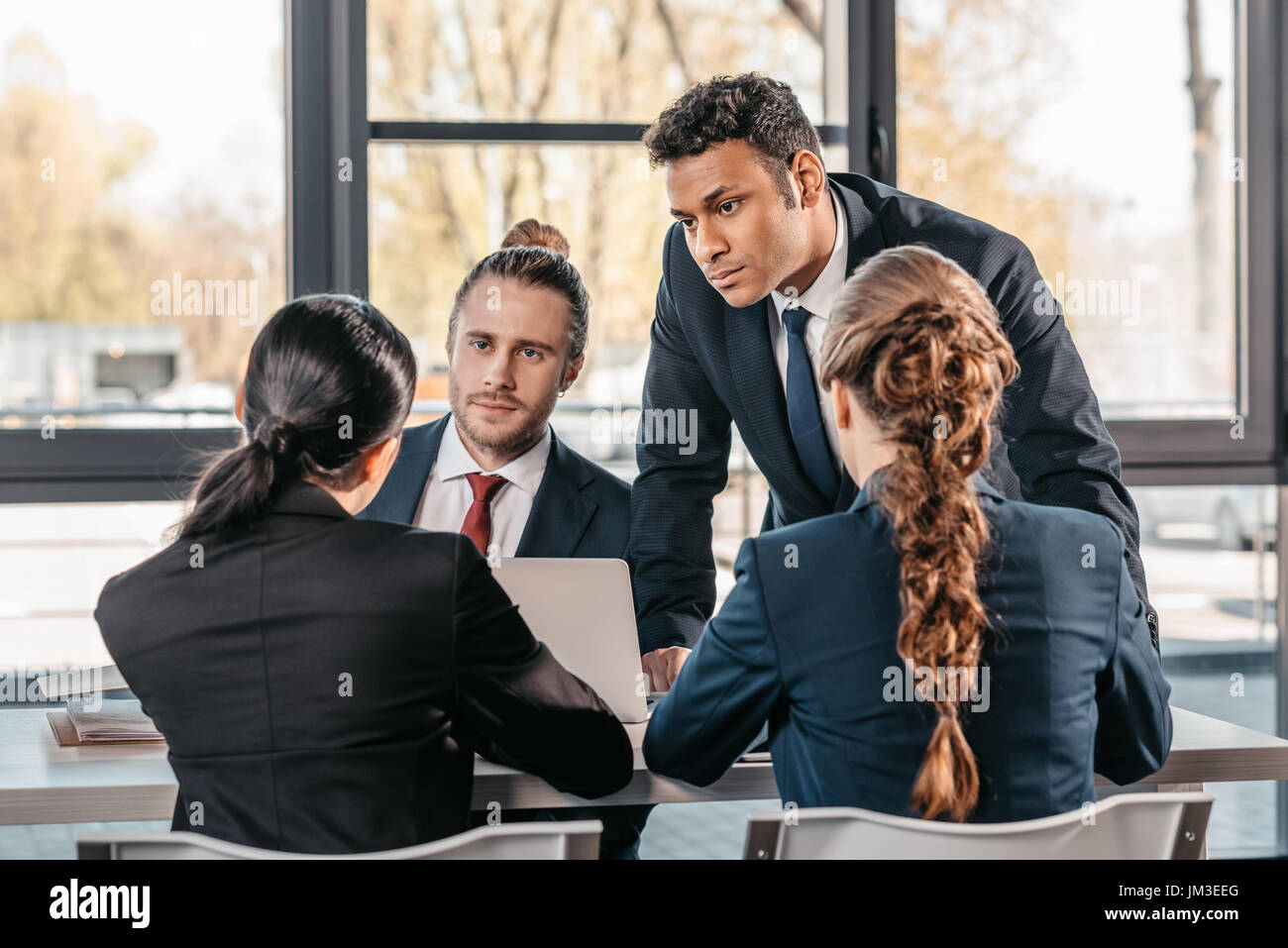 young coworkers in formalwear arguing at business meeting in office ...