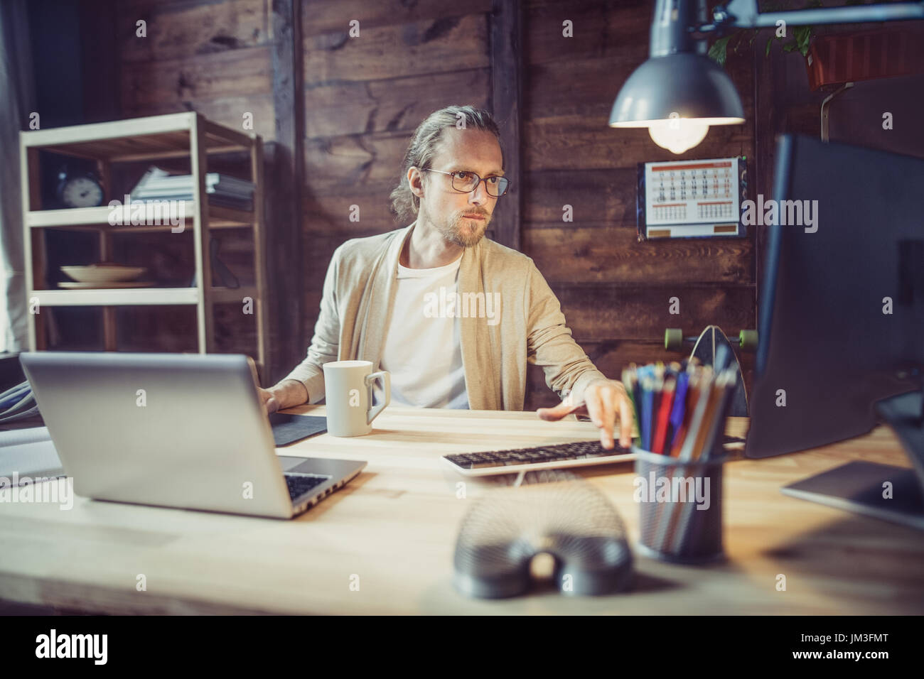 Freelancer man working with computer and laptop. Young man working at ...