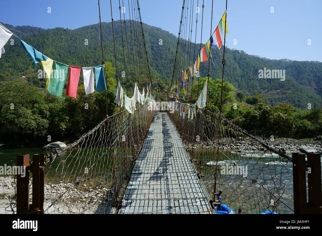 Suspension bridge across upper Punakha river with rafter getting ready ...