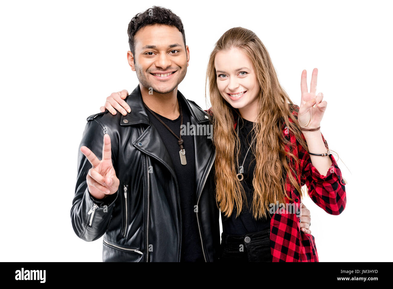 Smiling young couple standing embracing and showing peace sign isolated ...