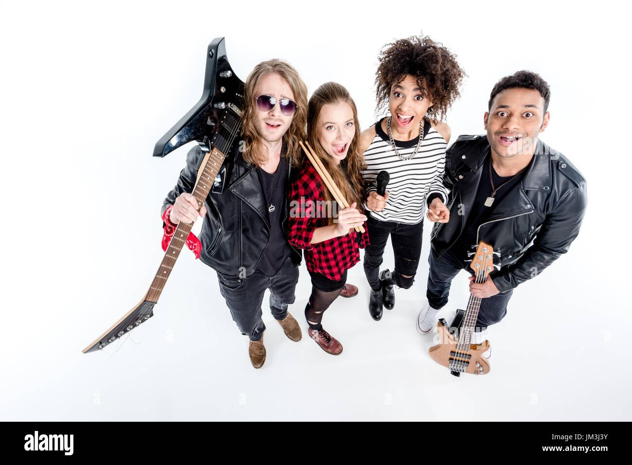 High angle view of young rock and roll band standing with microphone ...
