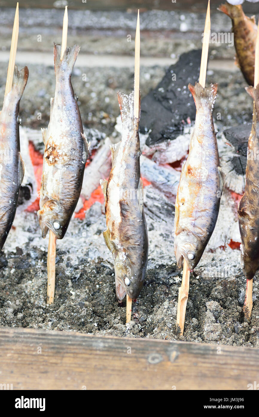 Japanese street food Grilled Ayu fish in vertical frame Stock Photo - Alamy