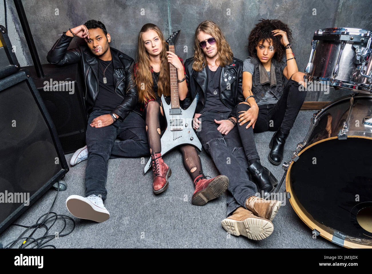 rock band sitting on floor while resting after rehearse in studio Stock ...