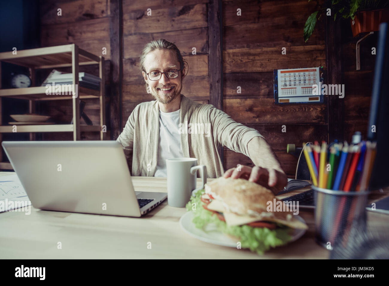 Freelancer man working at home going to have lunch break. Front view of ...