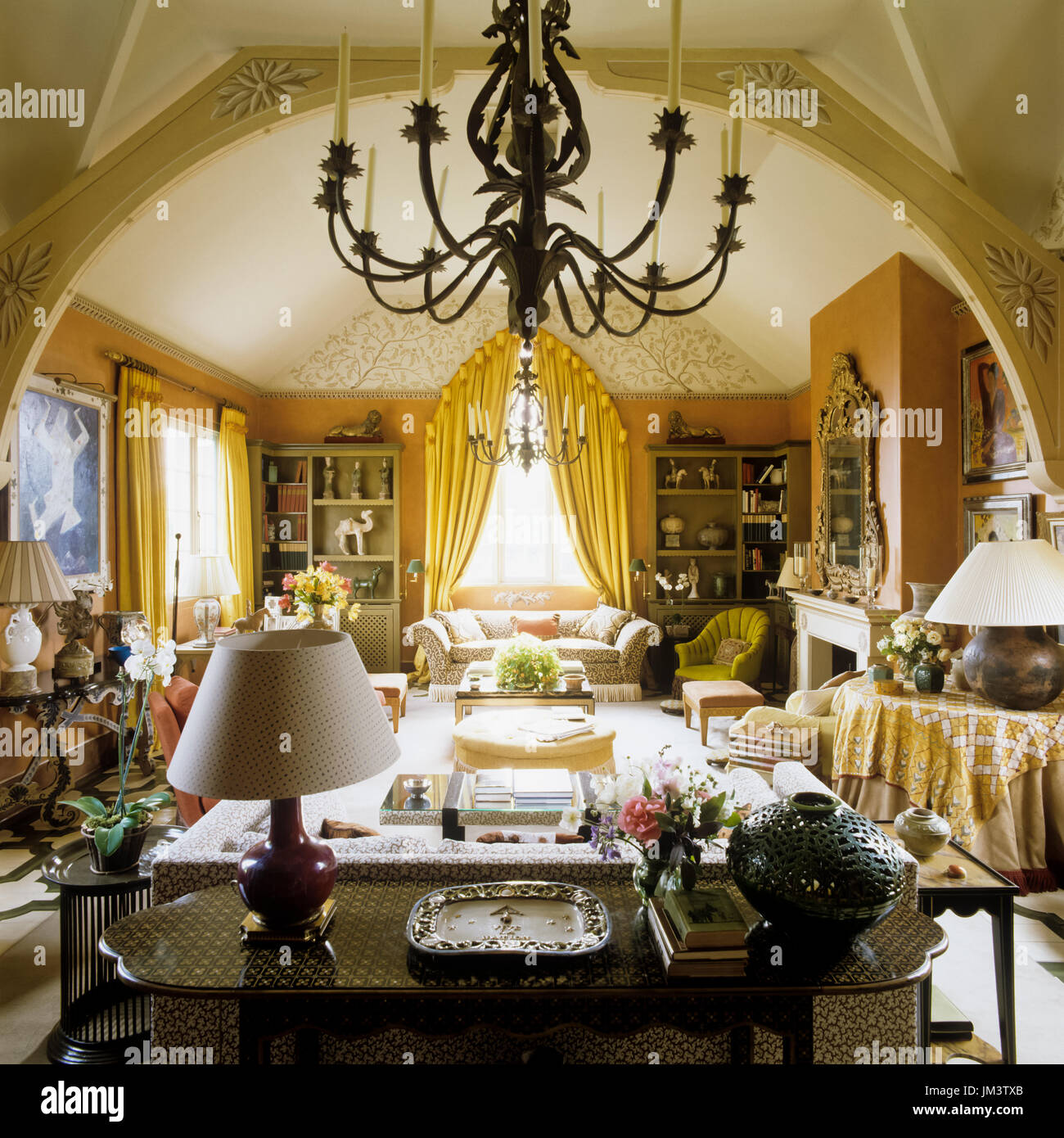 Yellow toned living room with chandelier Stock Photo - Alamy