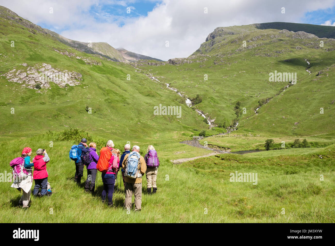 Hikers looking at view to Aonach Beag from Glen Nevis valley near Fort ...