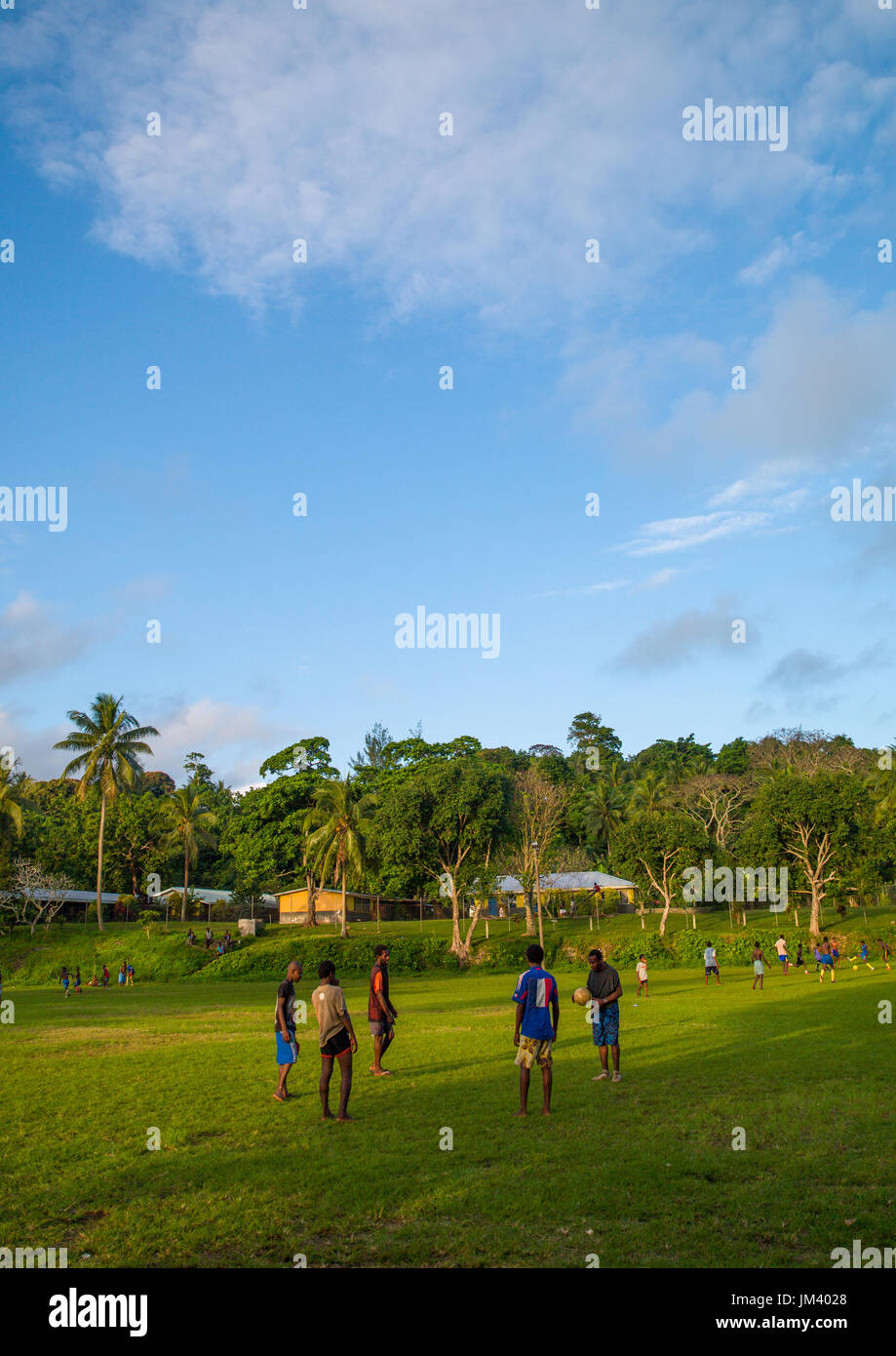 Teenagers playing football in a field, Shefa Province, Efate island ...