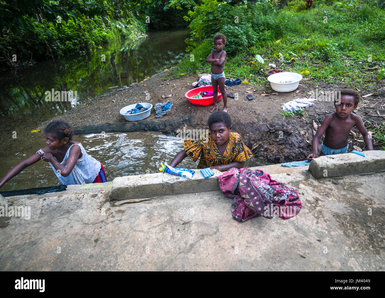 Woman and kids doing laundry in river, Shefa Province, Efate island ...